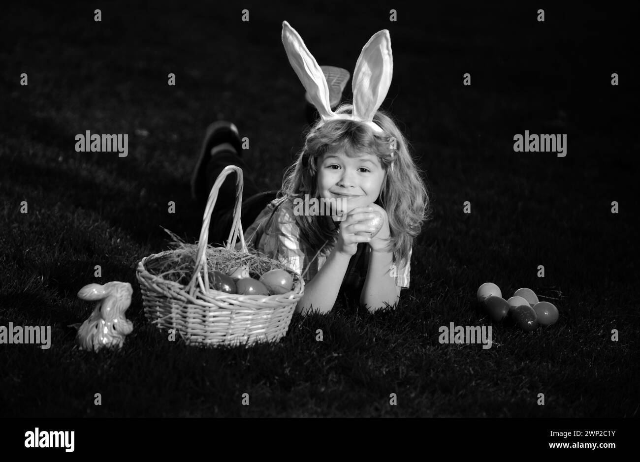 Kids hunting easter eggs in park laying on grass. Cute bunny child boy ...
