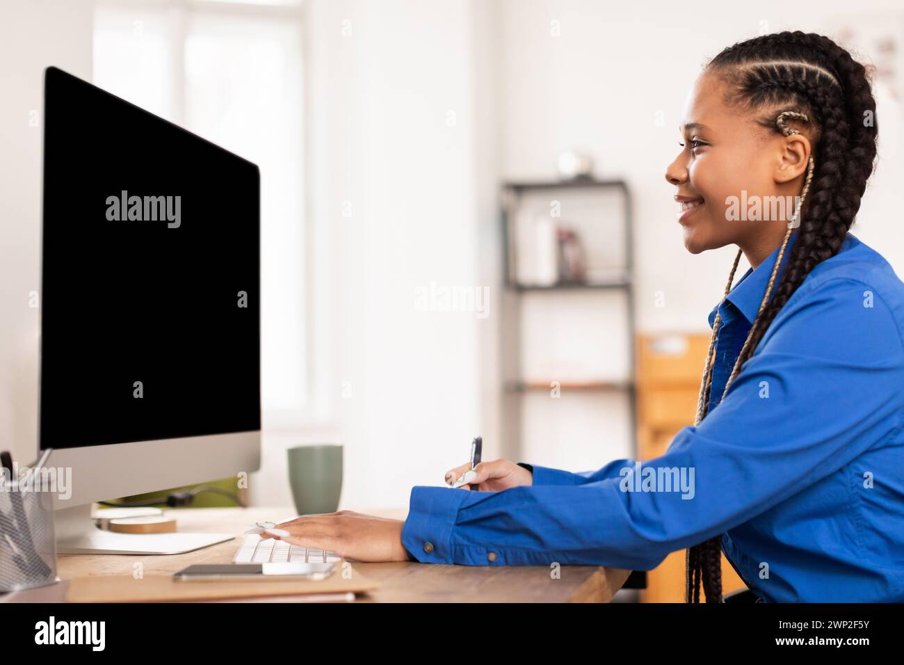 Focused female student engaged in online learning with computer at home ...