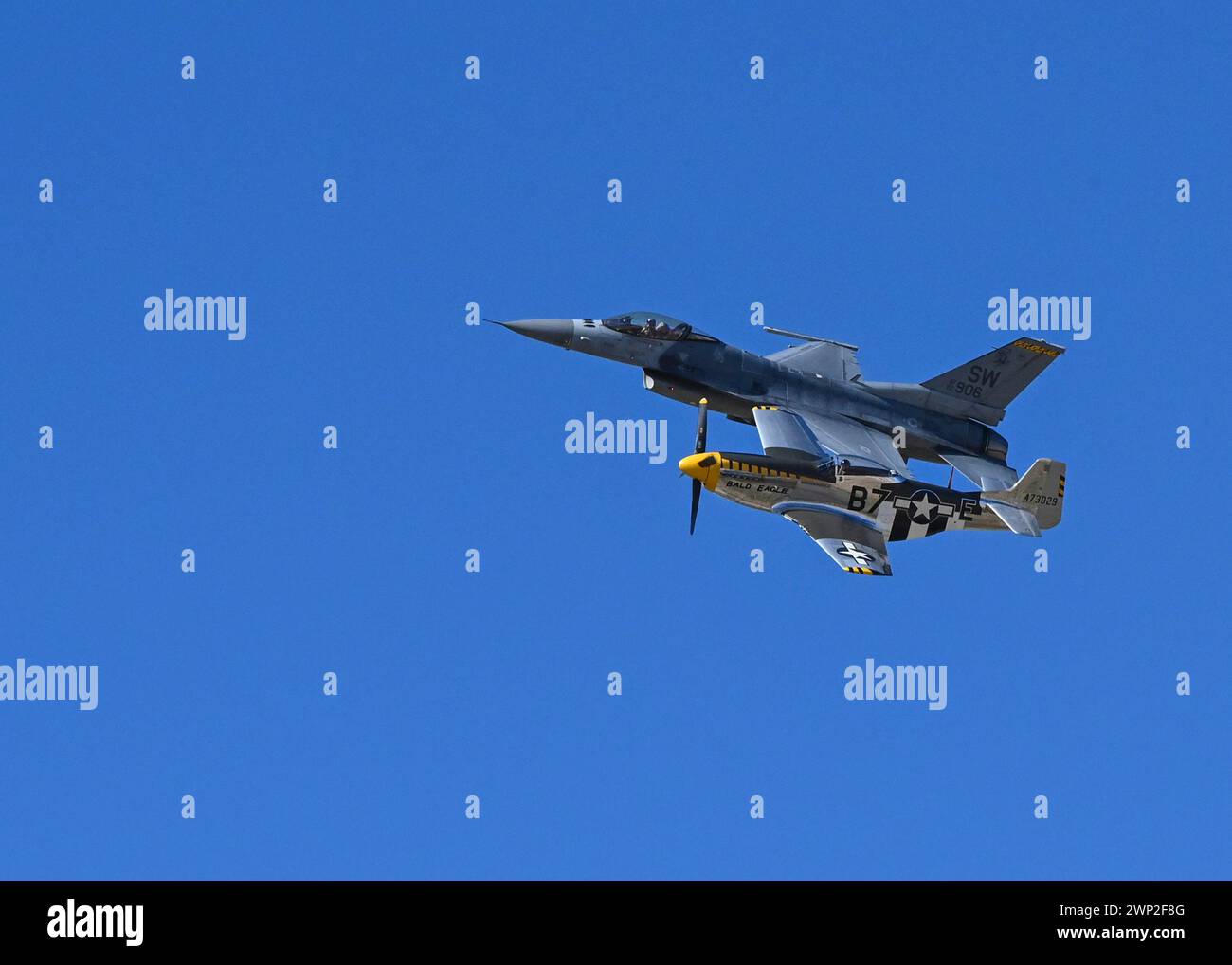 An F-16 Fighting Falcon aircraft flies alongside a P-51 Mustang during ...