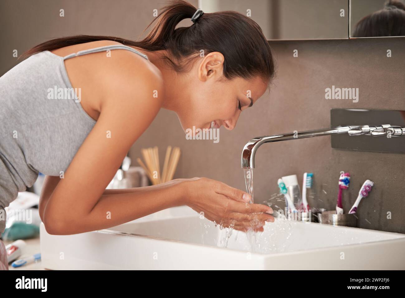 Bathroom, washing face and woman with water for skincare, beauty and ...