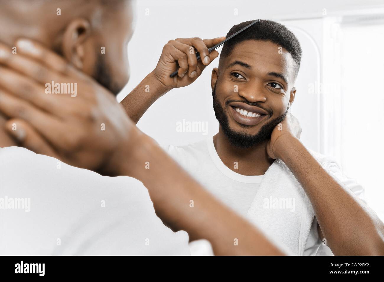 Combing man in bathroom Stock Photo - Alamy
