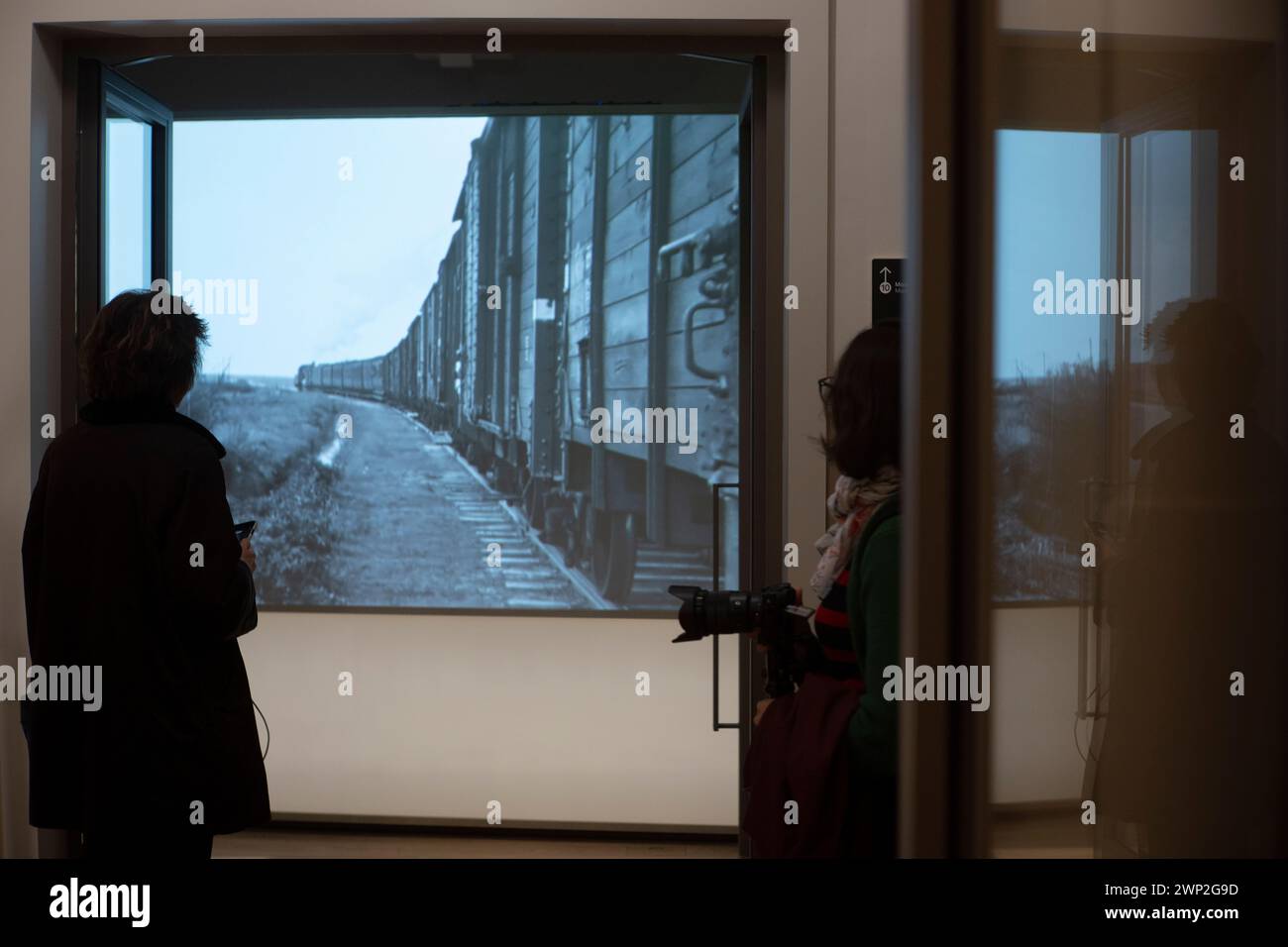 People look at historic footage of trains carrying Jews to Nazi ...