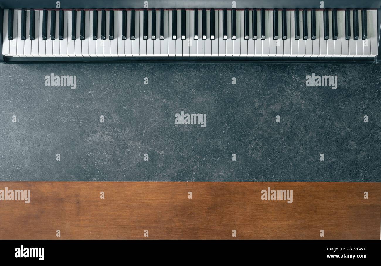 Piano keyboard on a dark marble and wood surface, top view Stock Photo ...