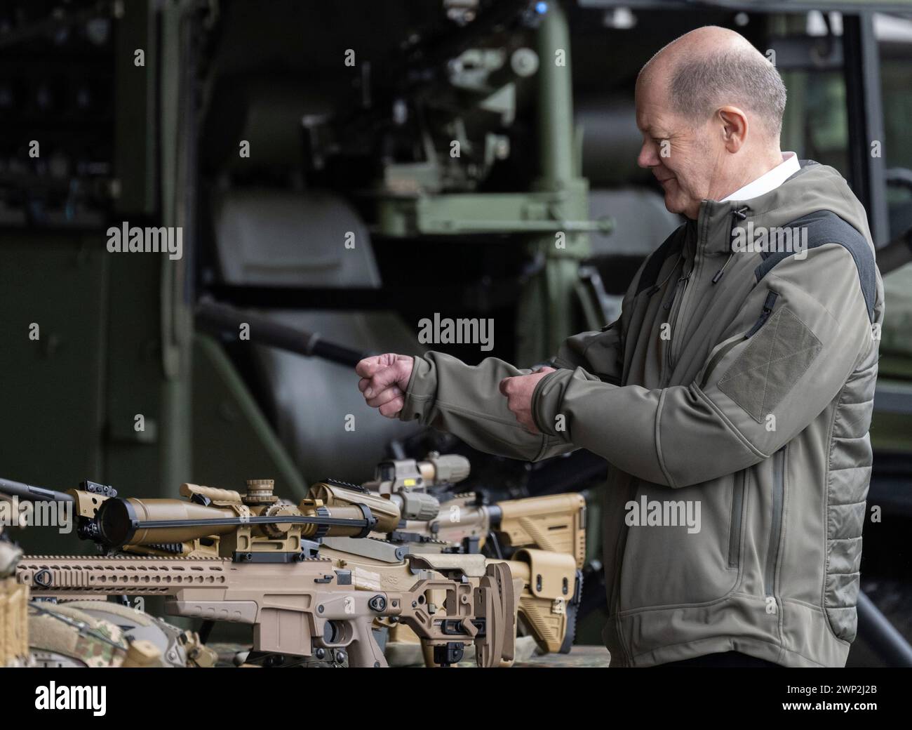 German Chancellor Olaf Scholz tests how to hold a weapon during a visit ...