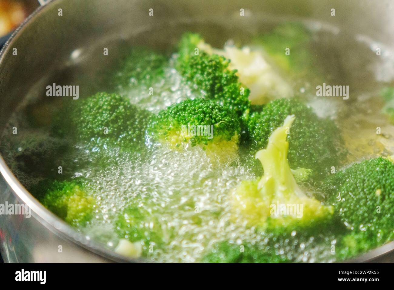 Vibrant broccoli to a bubbling pot of boiling water, creating a ...