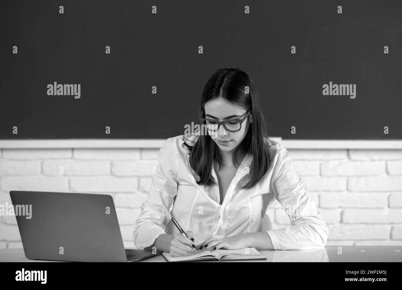 Student preparing exam and learning lessons in school classroom. Female ...