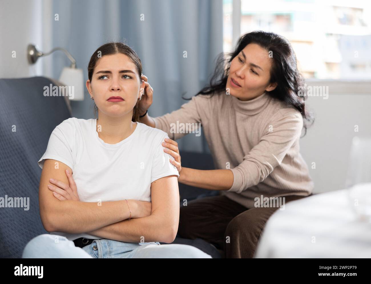 Girl comforting her upset friend on the couch Stock Photo - Alamy