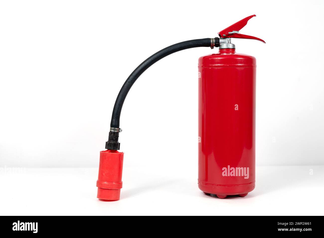 A red cylinder fire extinguisher with a black hose, contrasting on a ...