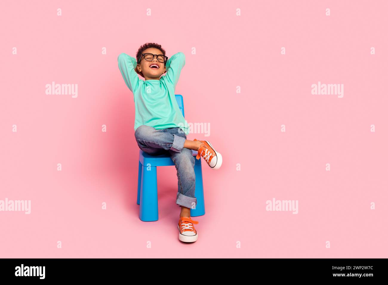 Full length photo of adorable little boy sit chair hands behind head ...
