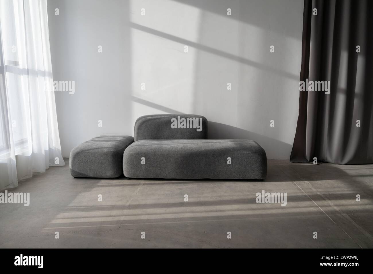 stylish grey sofa in the loft with a window shadow on the wall Stock ...