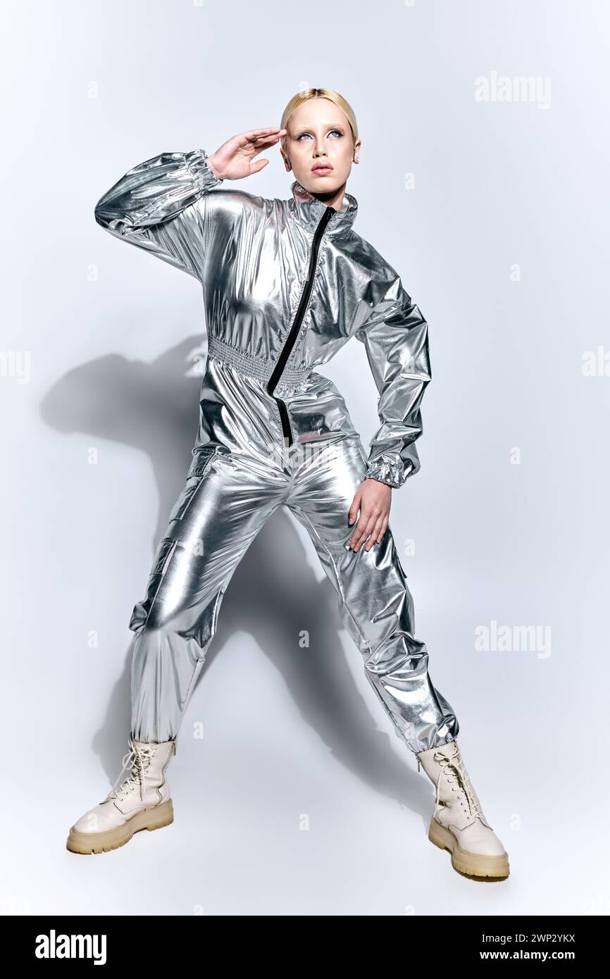 extraordinary woman in silver futuristic attire posing in motion on ...