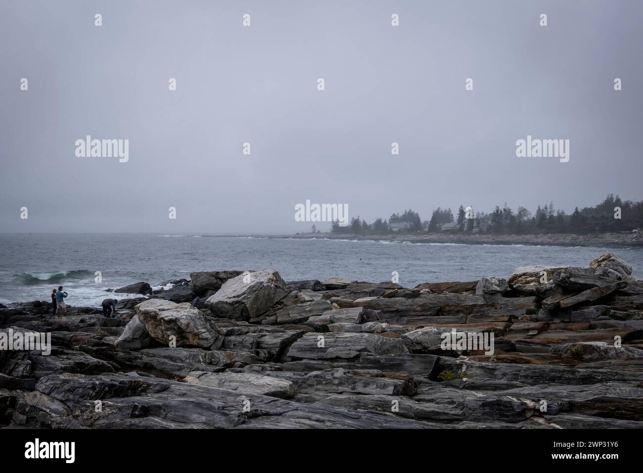 Pemaquid Point, Maine with cloudy sky above and the massive rock ledges ...