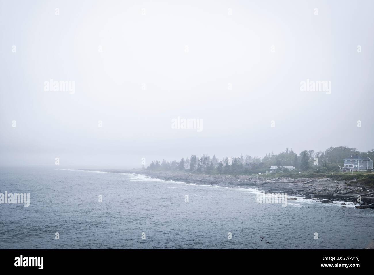Pemaquid Point, Maine with cloudy sky above and the massive rock ledges ...