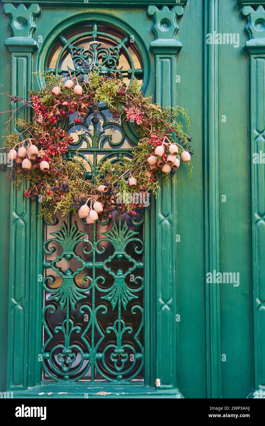A wood door with a wreath, a charming fixture on a buildings facade ...