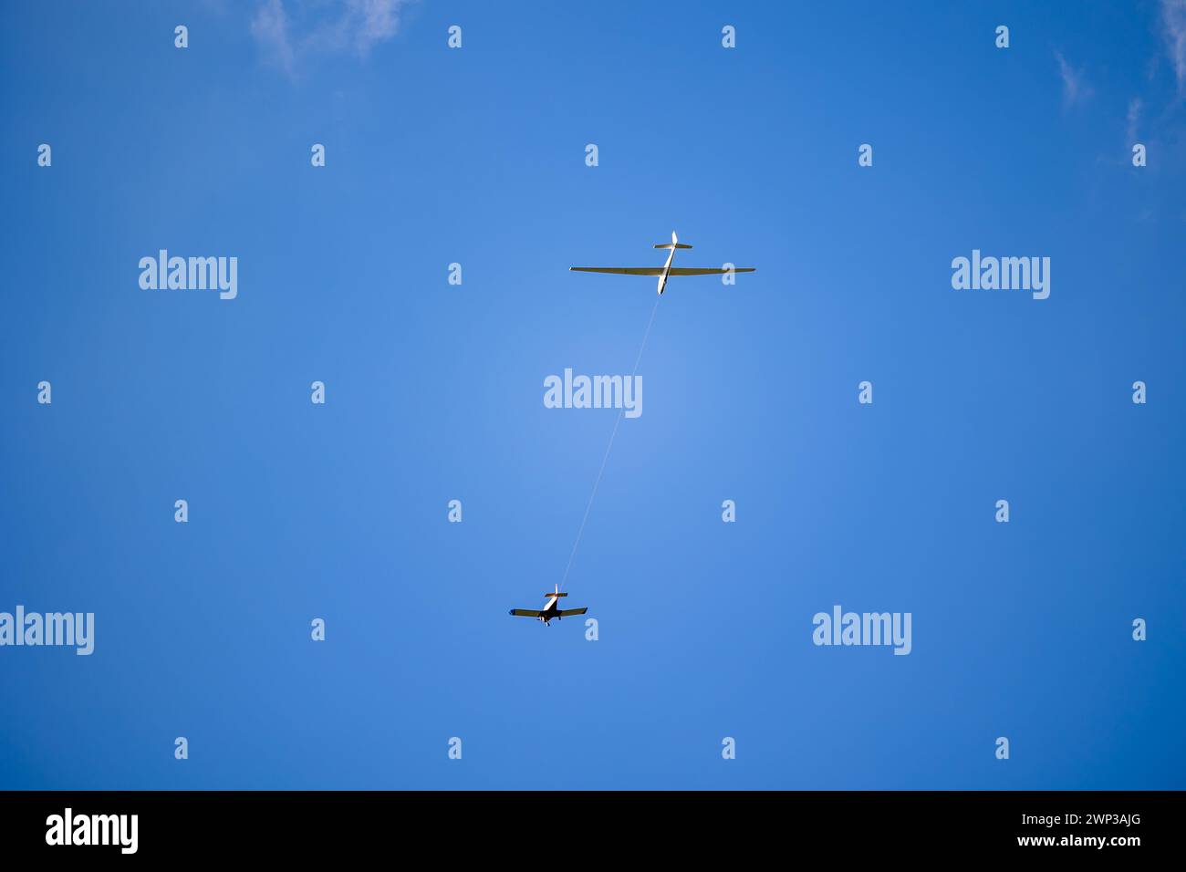 White glider plane being pulled by other small airplane towards the ...