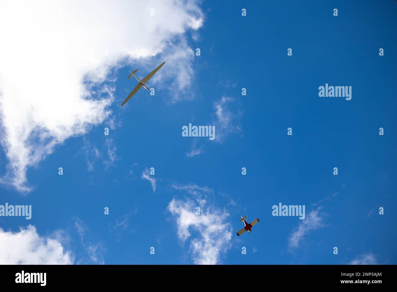 White glider plane being pulled by other small airplane towards the ...