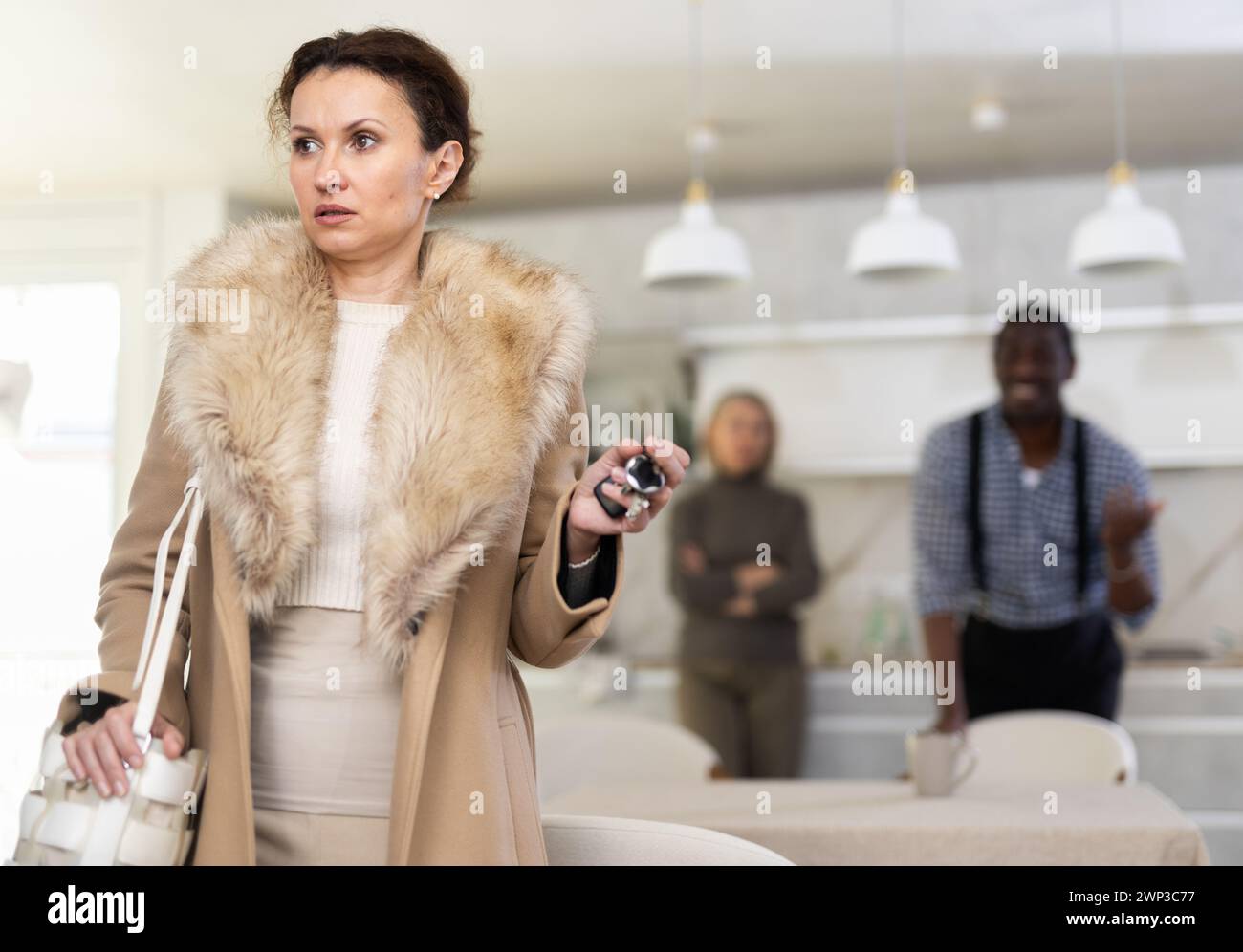 Middle-aged woman ready to leave standing with her back to man and old ...