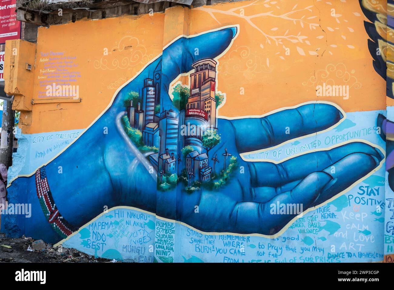 A mural depicting a hand holding a city is seen painted on a wall in ...