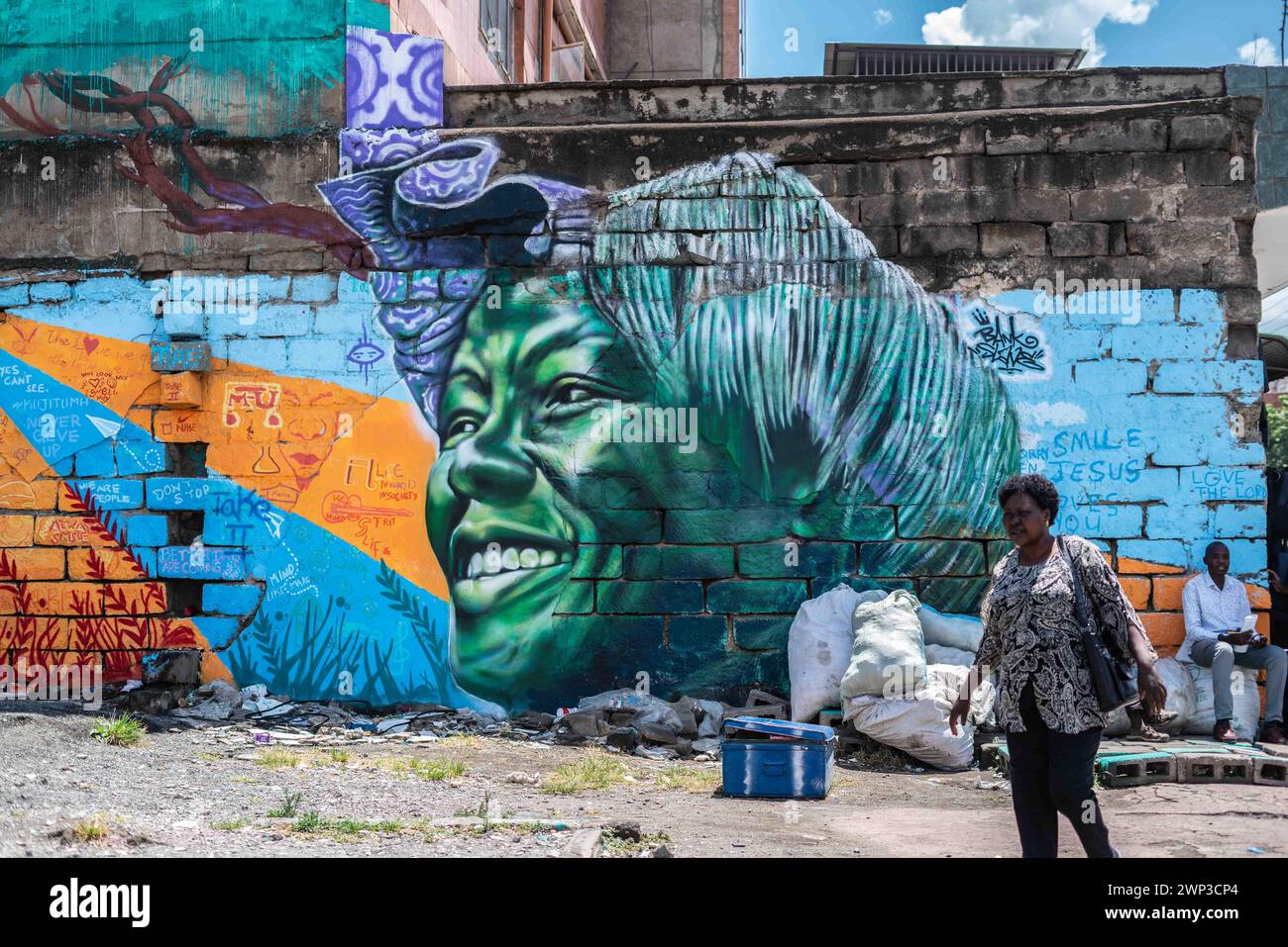 A woman walks past a mural of the late Kenyan environmentalist Wangari ...