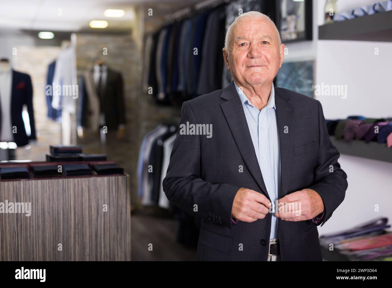 Mature male shopper shows off his jacket at men's store Stock Photo - Alamy