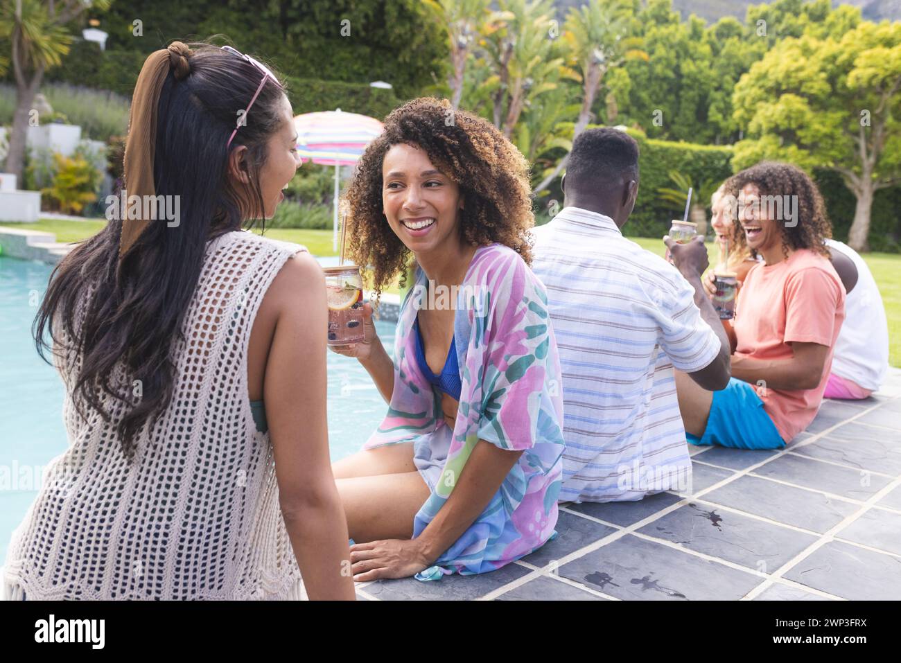 Diverse group of friends enjoys a poolside gathering, sharing laughter ...