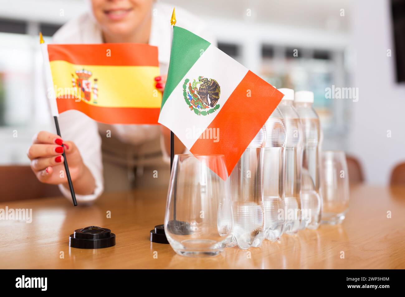Unrecognizable girl sets midget flags of Mexico and Spain before ...