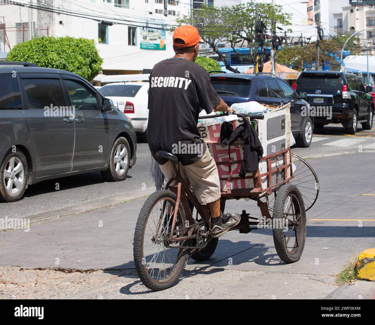 A man pedals his tricycle cart of recyclable goods he has collected in ...