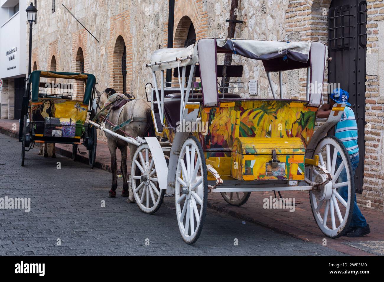 Painted horse-drawn carriages waiting for passengers in the old ...