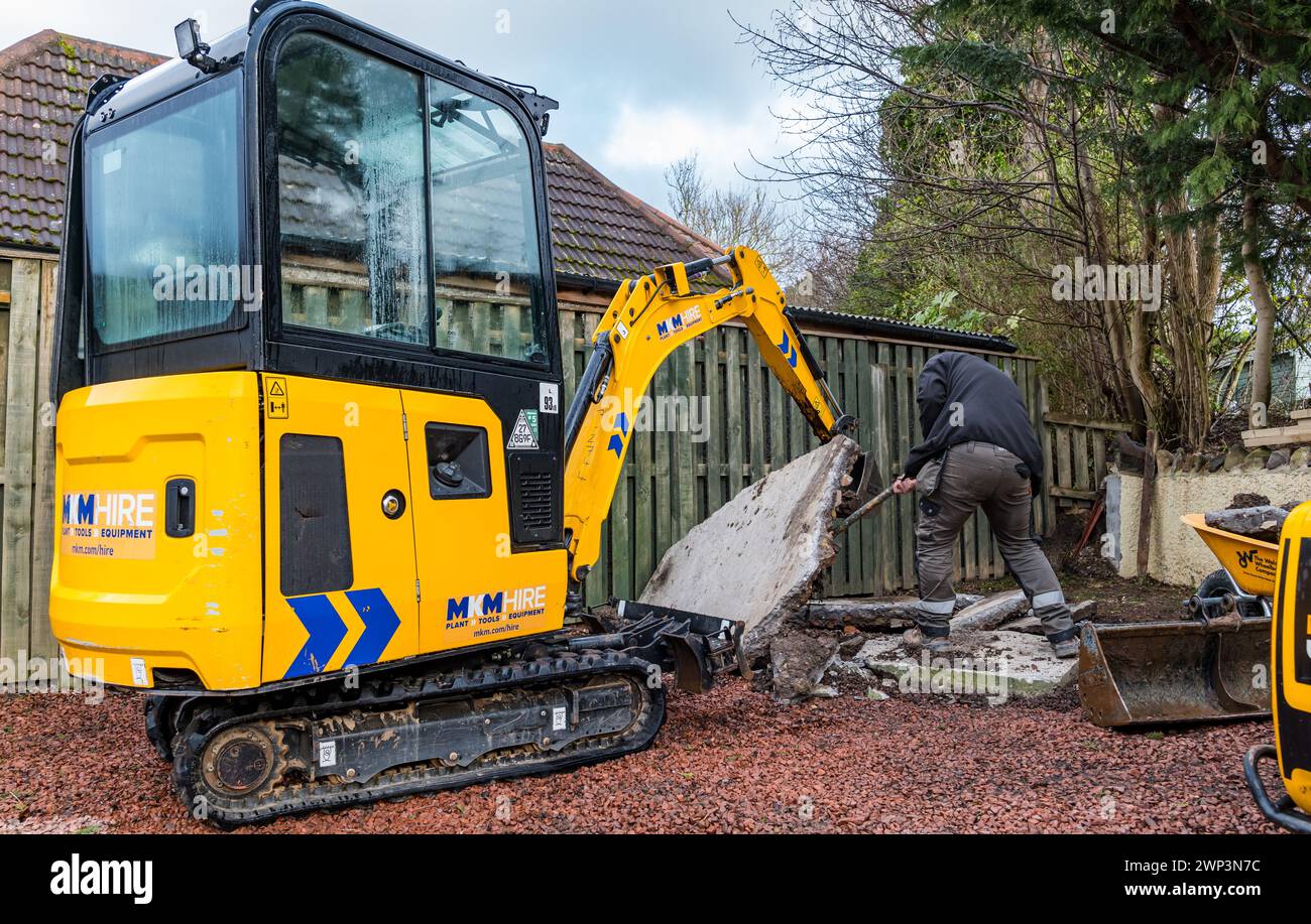 Construction work by workmen in a driveway to remove concrete, Scotland ...
