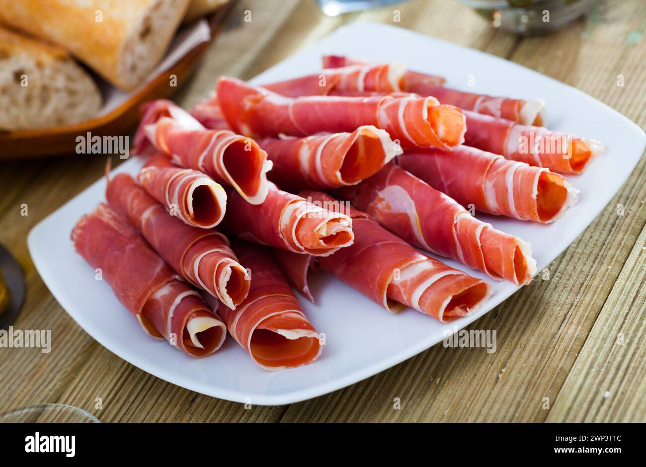 Traditional Spanish meal - rolls of iberian jamon served at plate Stock ...