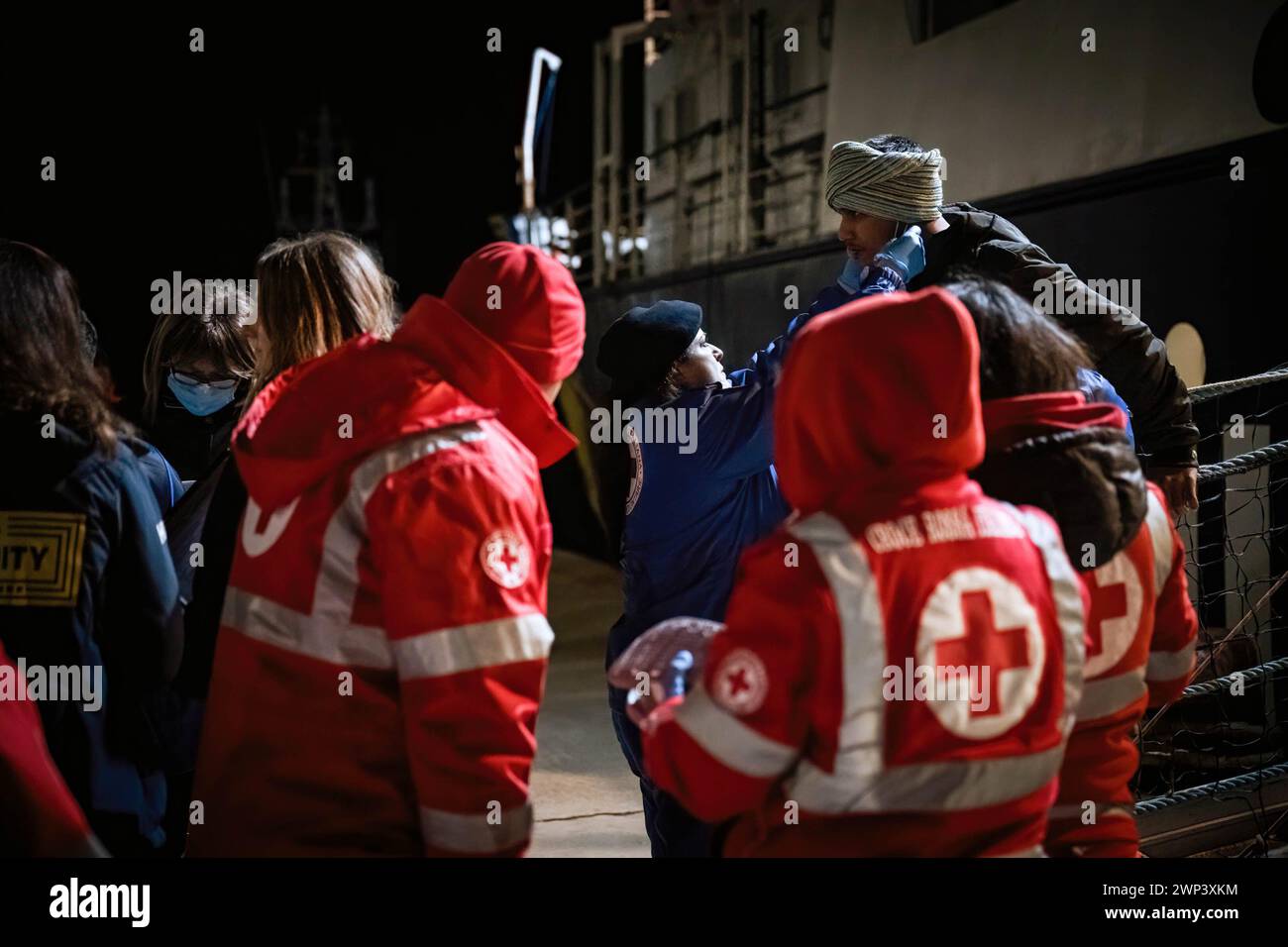 A member of the Red Cross seen helping a migrant. The rescue ship ...