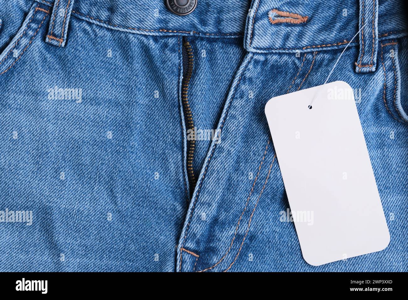 Denim pants with an unbuttoned fly and label hanging on them Stock ...