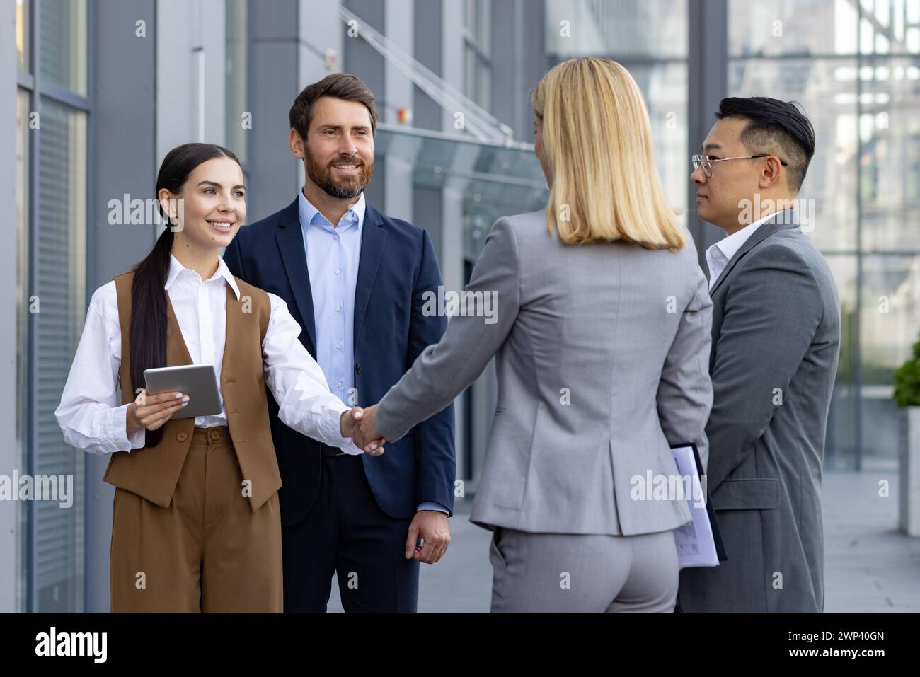 A diverse group of business professionals engaging in a handshake ...