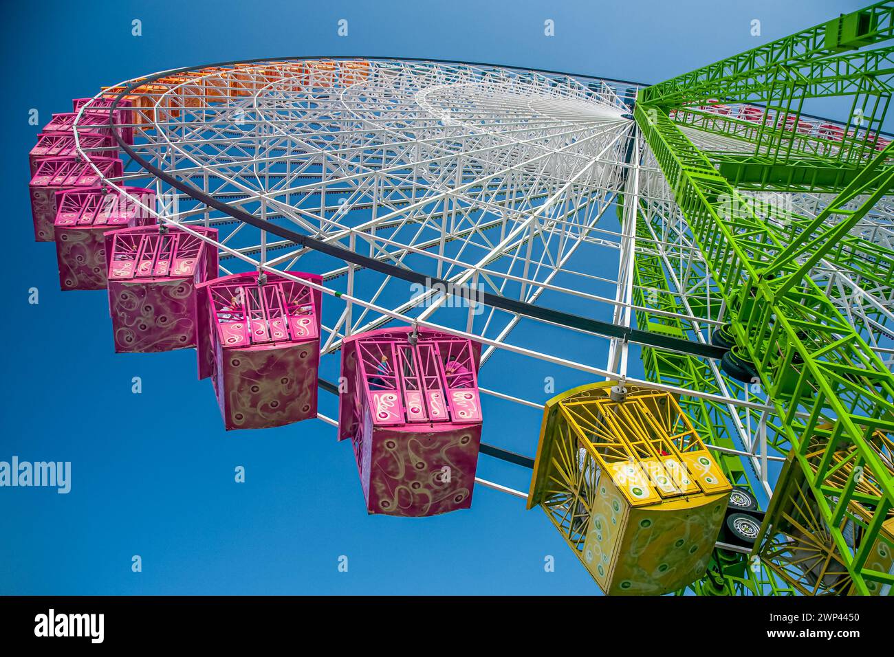 A colorful ferris wheel towers under a clear blue sky Stock Photo - Alamy