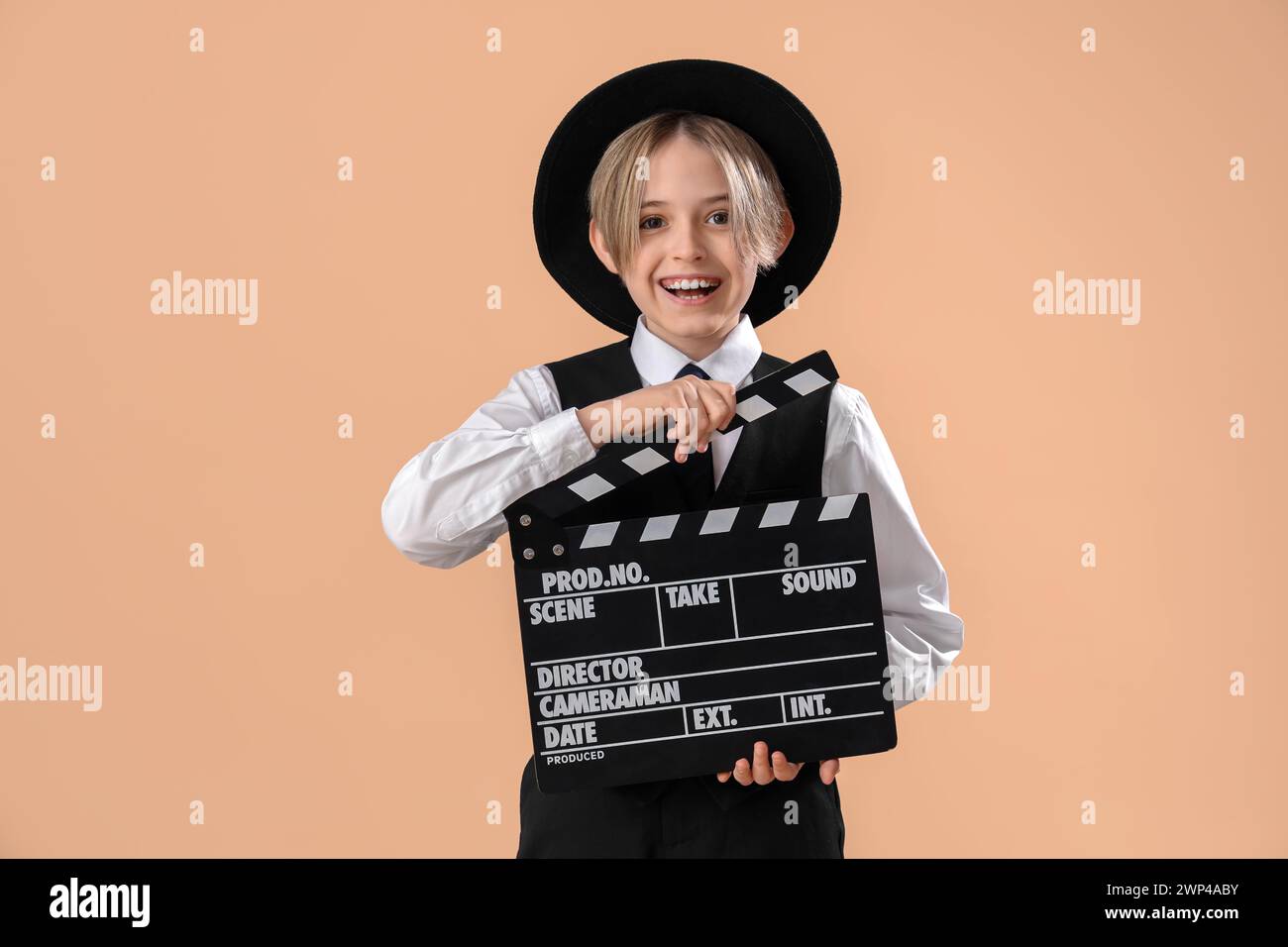 Little actor with movie clapper on beige background Stock Photo - Alamy