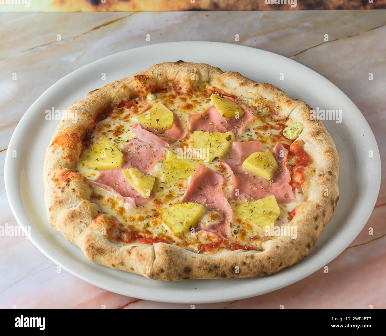 Tropical Hawaiian pizza with pineapple slices and ham on a baked dough ...