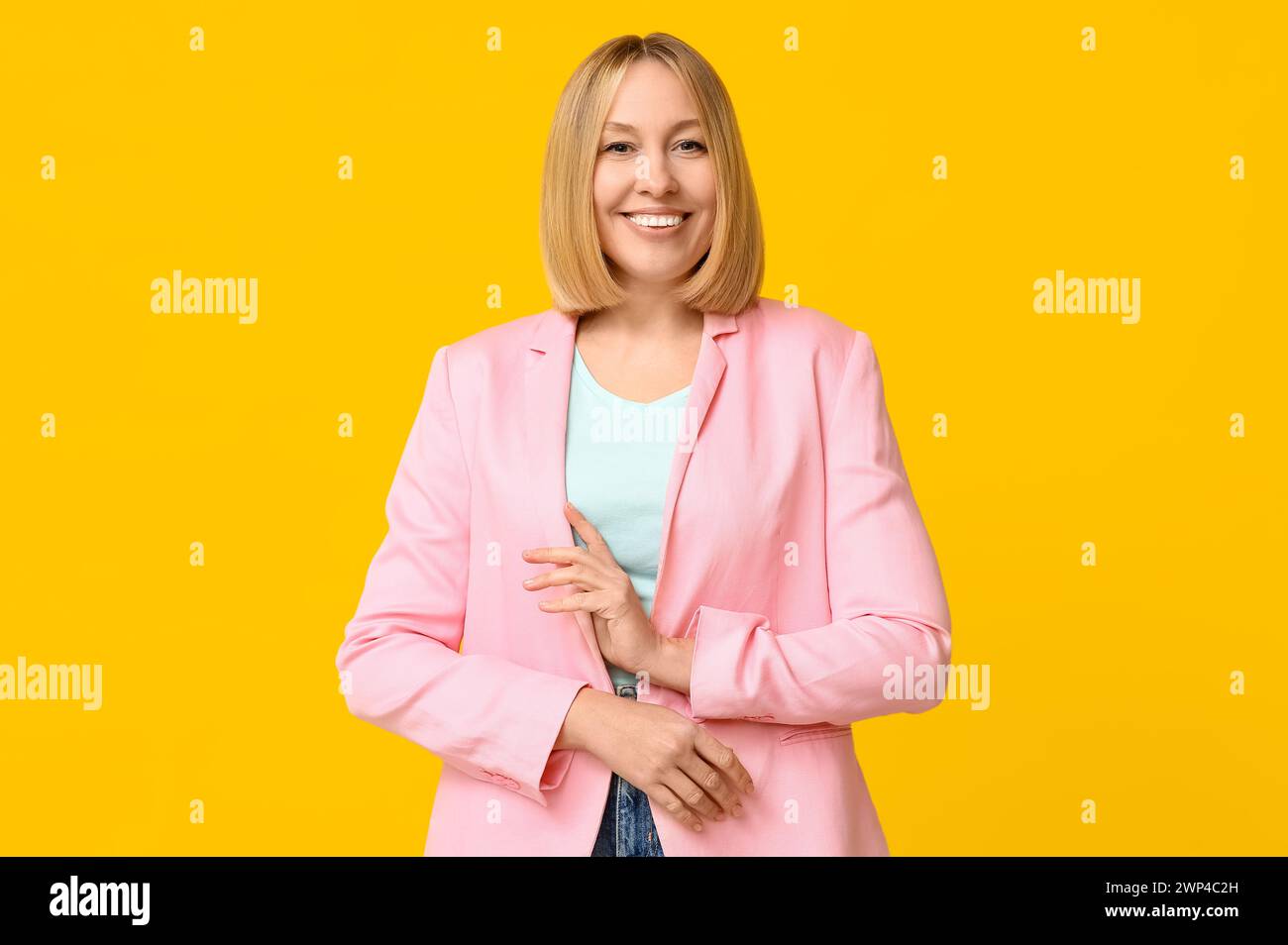 Happy young woman with bob hairstyle on yellow background Stock Photo ...