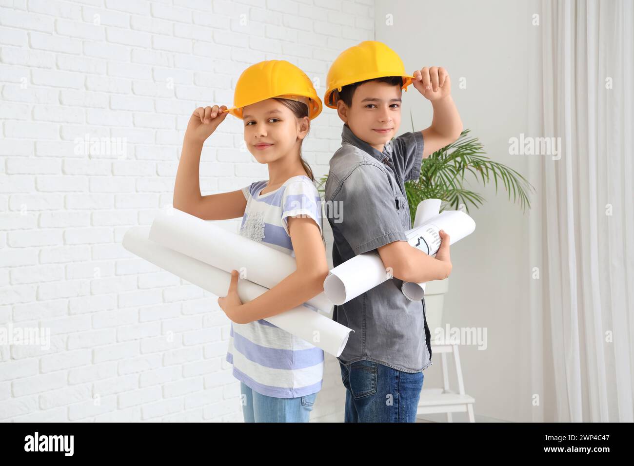 Little architects with house plans in room Stock Photo - Alamy