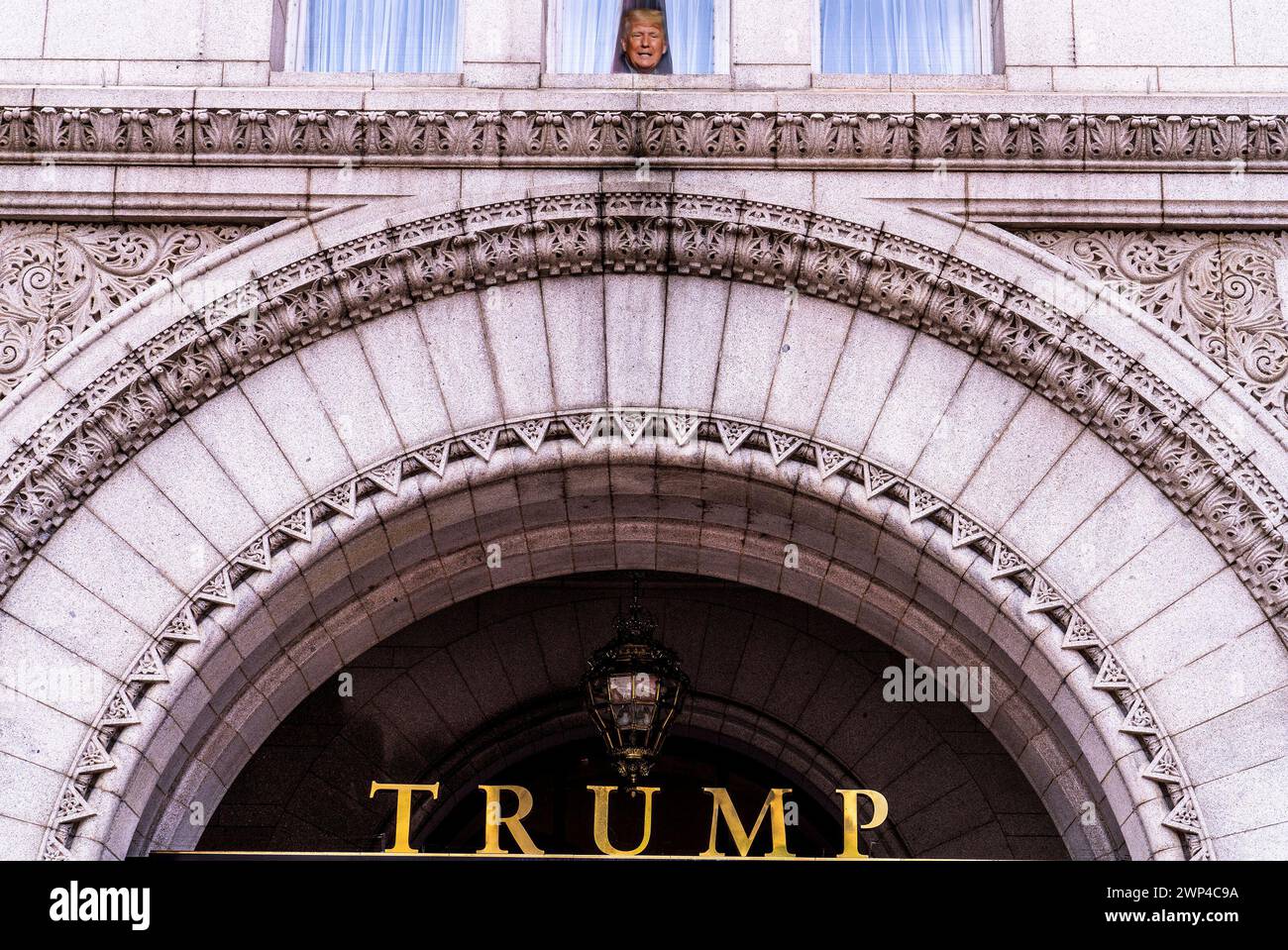 A figure peers out of the window of the Trump International Hotel in ...