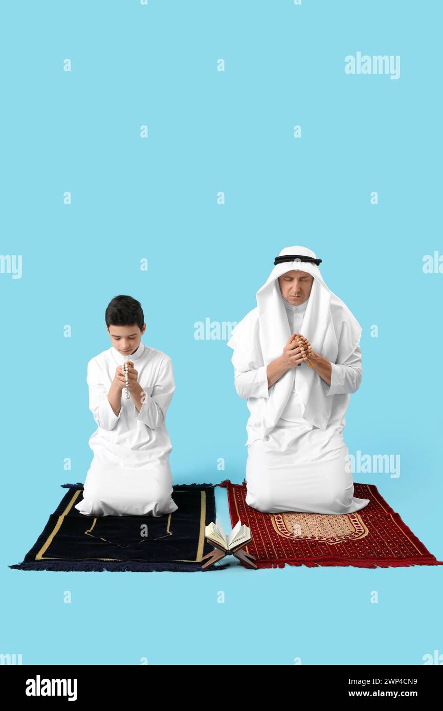 Muslim father and his son praying on blue background. Eid al-Fitr ...