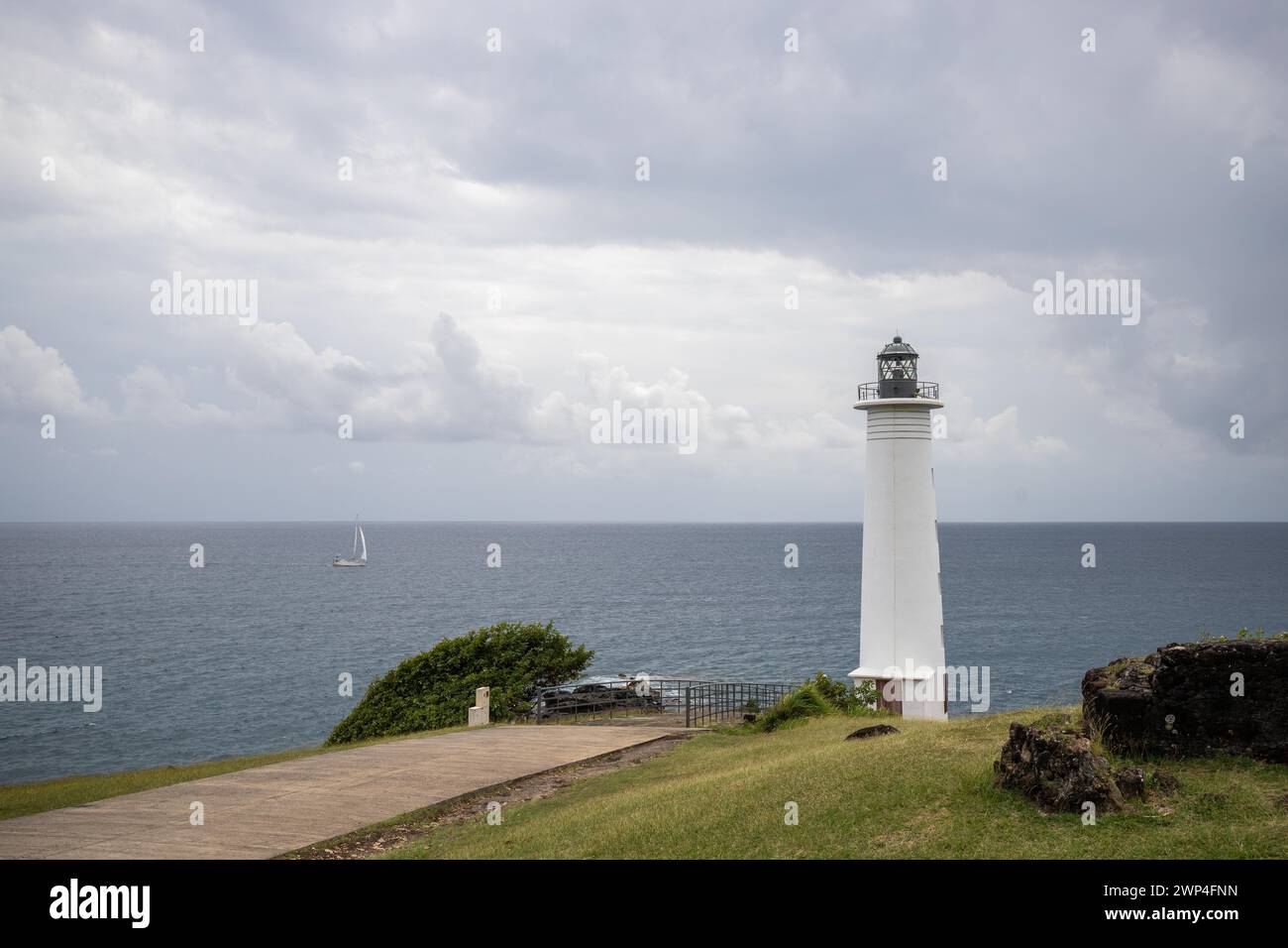White lighthouse on a steep coast. Dramatic clouds with a view of the ...