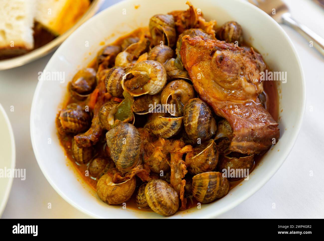 Stewed snails with rabbit meat and sausages Stock Photo - Alamy