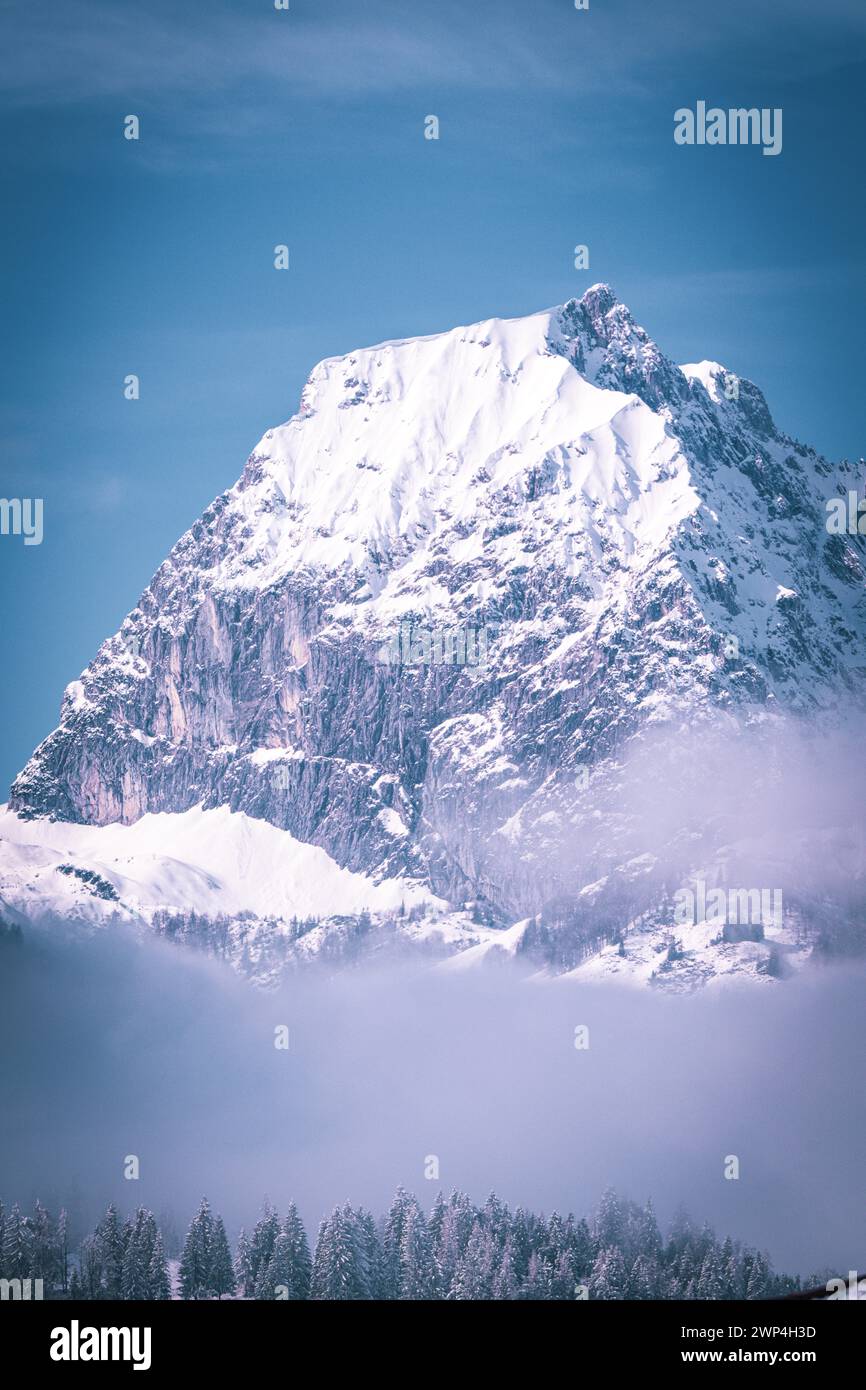 Prominent snowy mountain peak against a clear blue sky, Kaisergebierge ...