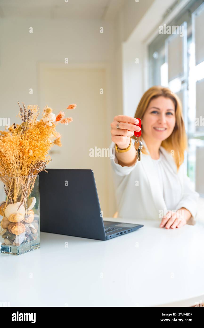 Vertical photo of an elegant female real estate agent delivering the ...