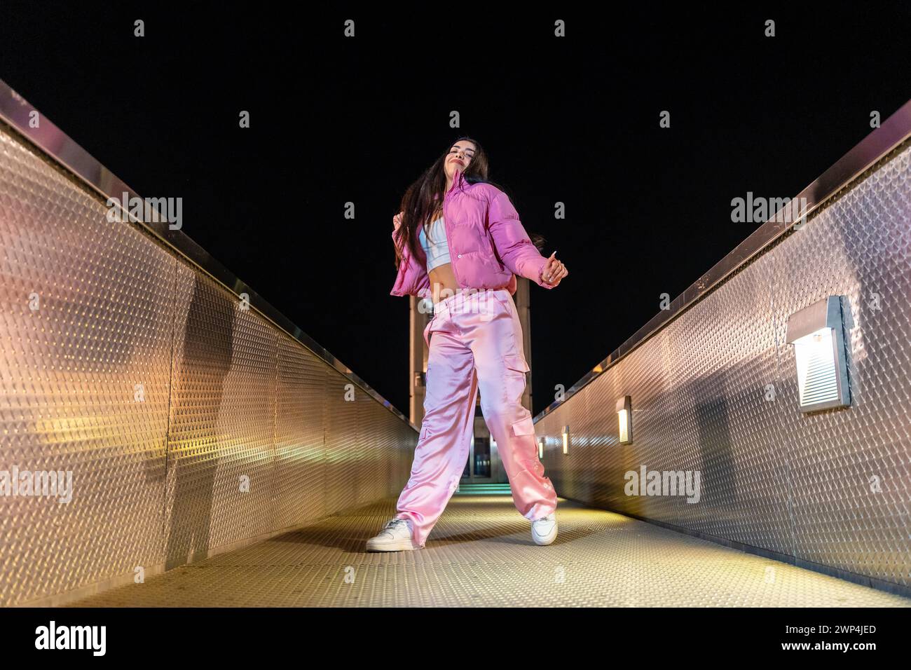 Low angle view photo of a young artist dancing hip hop on a bridge at ...