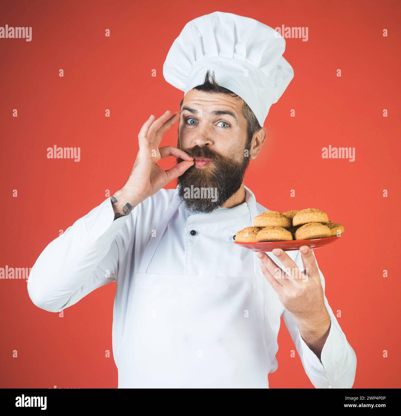 Male chef with plate oatmeal cookies showing ok sign. Smiling chef ...