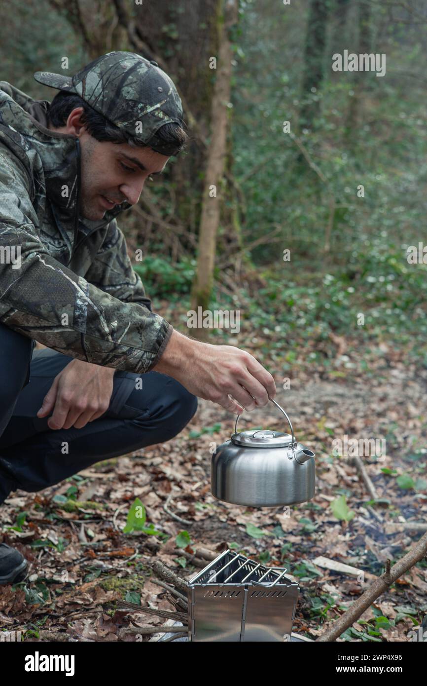 lateral view of an explorer clad in camouflage clothing crouching down ...