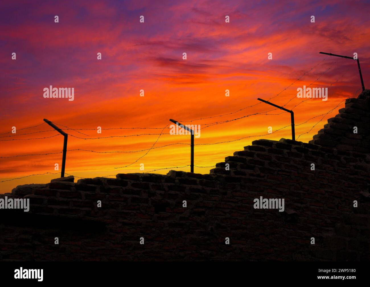 Prison wall and electric fences at sunset. freedom themed photo Stock ...