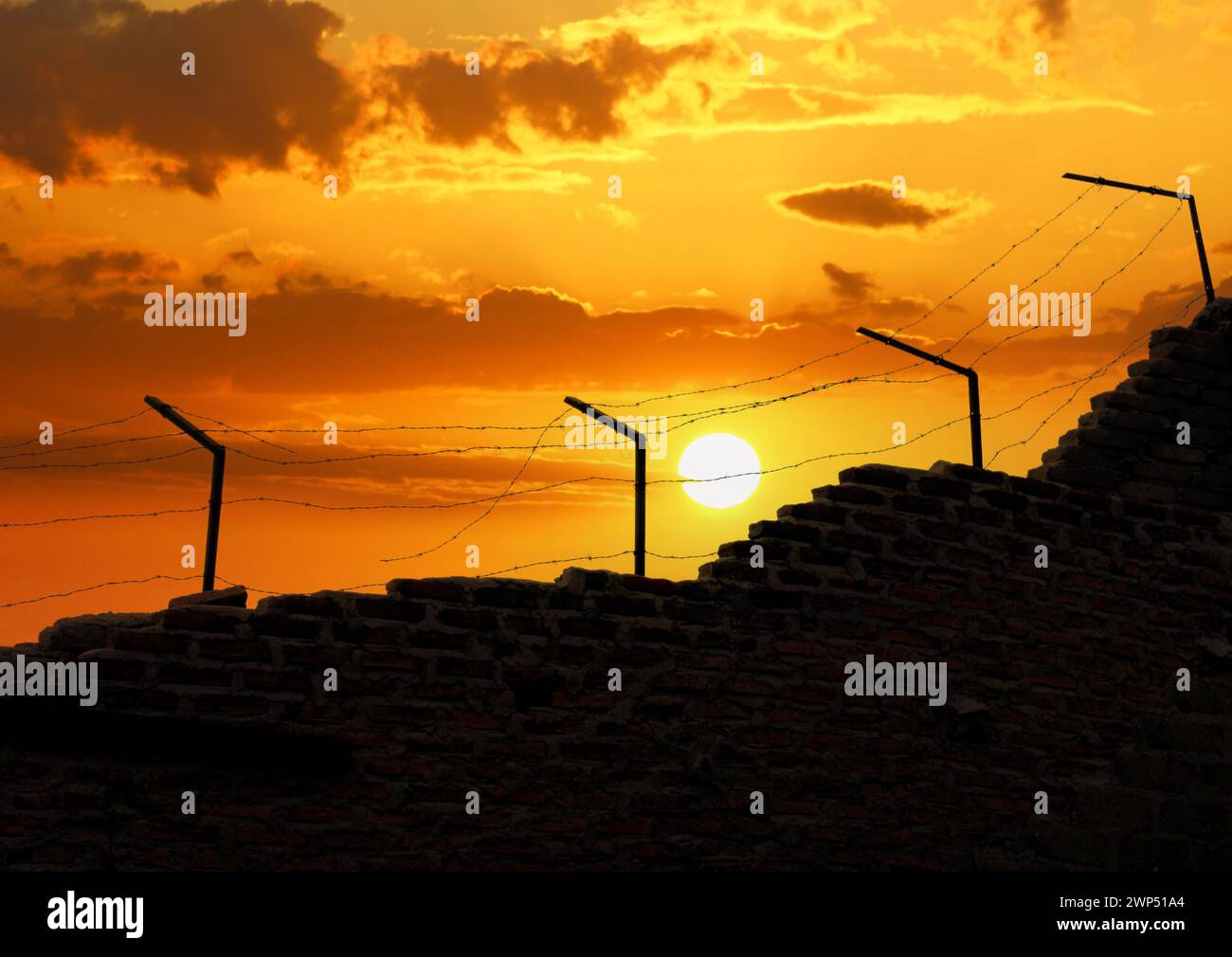 Prison wall and electric fences at sunset. freedom themed photo Stock ...