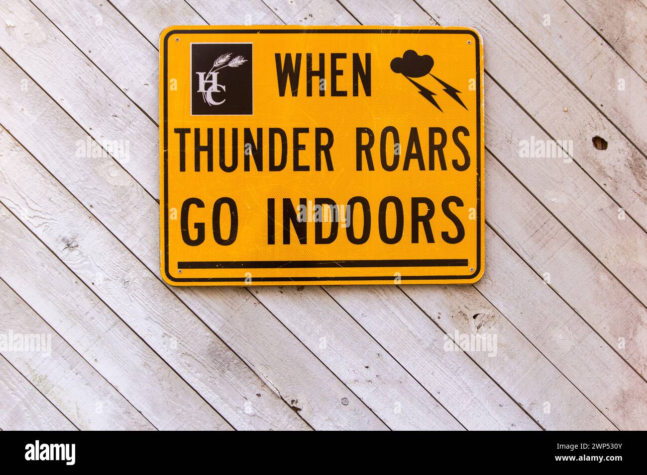 Yellow safety sign with black text that reads "When thunder roars, go ...